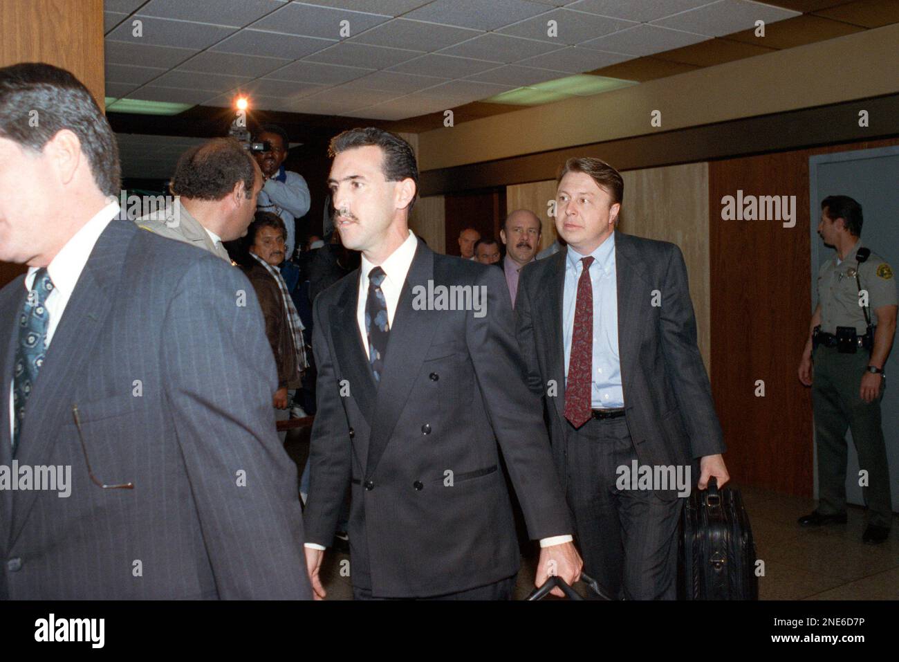 Los Angeles police officer Ted Briseno, left, arrives at a Los Angeles ...