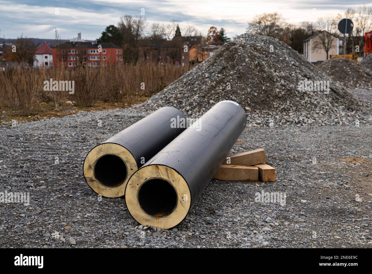 Cut pipes with thermal insulation lie on the construction site. Heap of ...