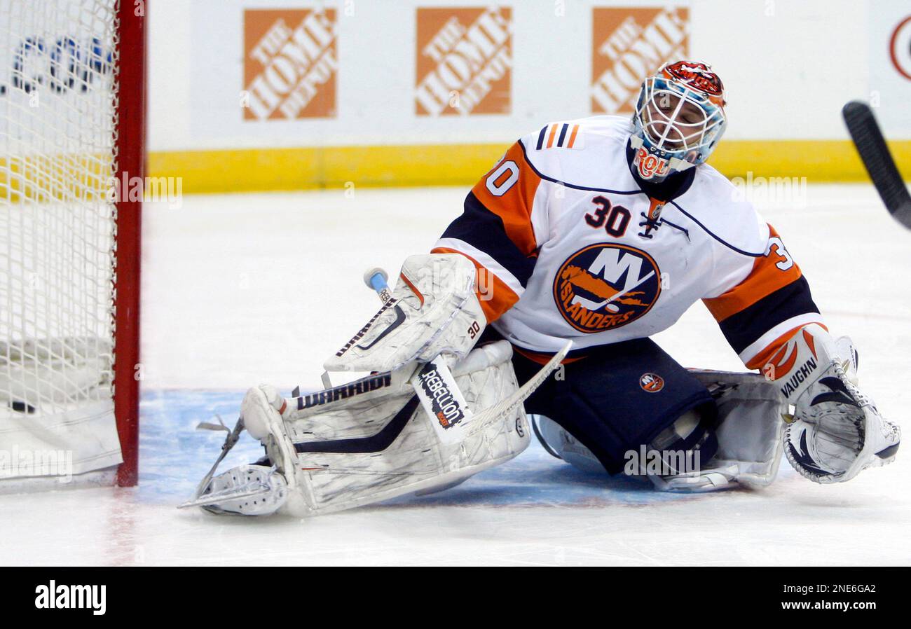 The puck gets past New York Islanders goalie Dwayne Roloson for an ...