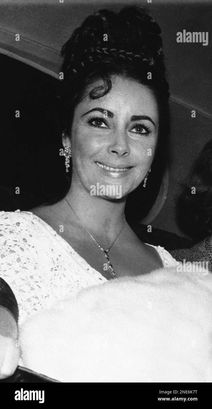 Actress Elizabeth Taylor smiles as she drives from the Dorchester Hotel ...