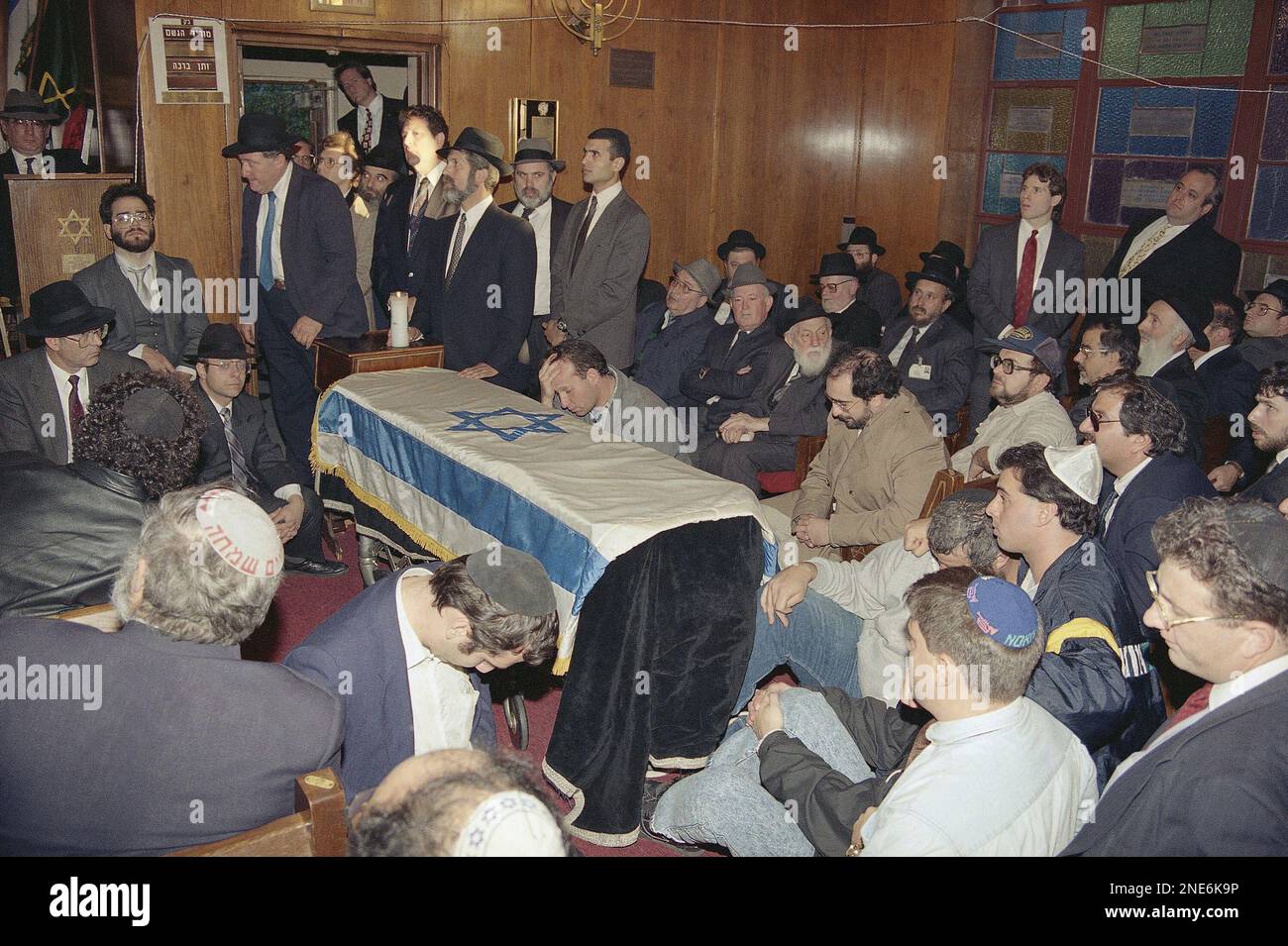Mourners kneel around the casket of Rabbi Meir Kahane during a memorial ...