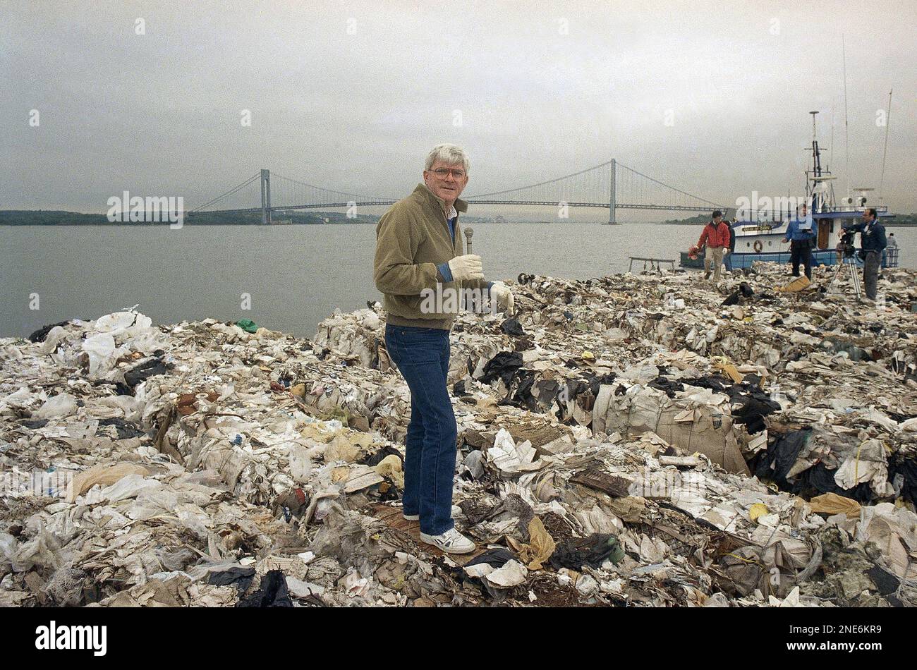 Phil Donahue, wearing white gloves, gestures while taping his NBC television show atop a barge ...