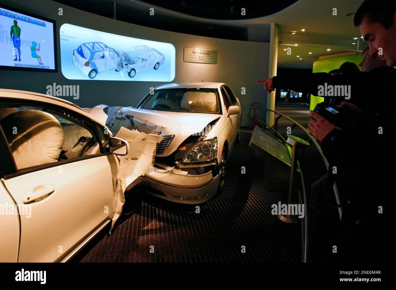 Visitors look at crashed cars with airbags deployed as part of the ...