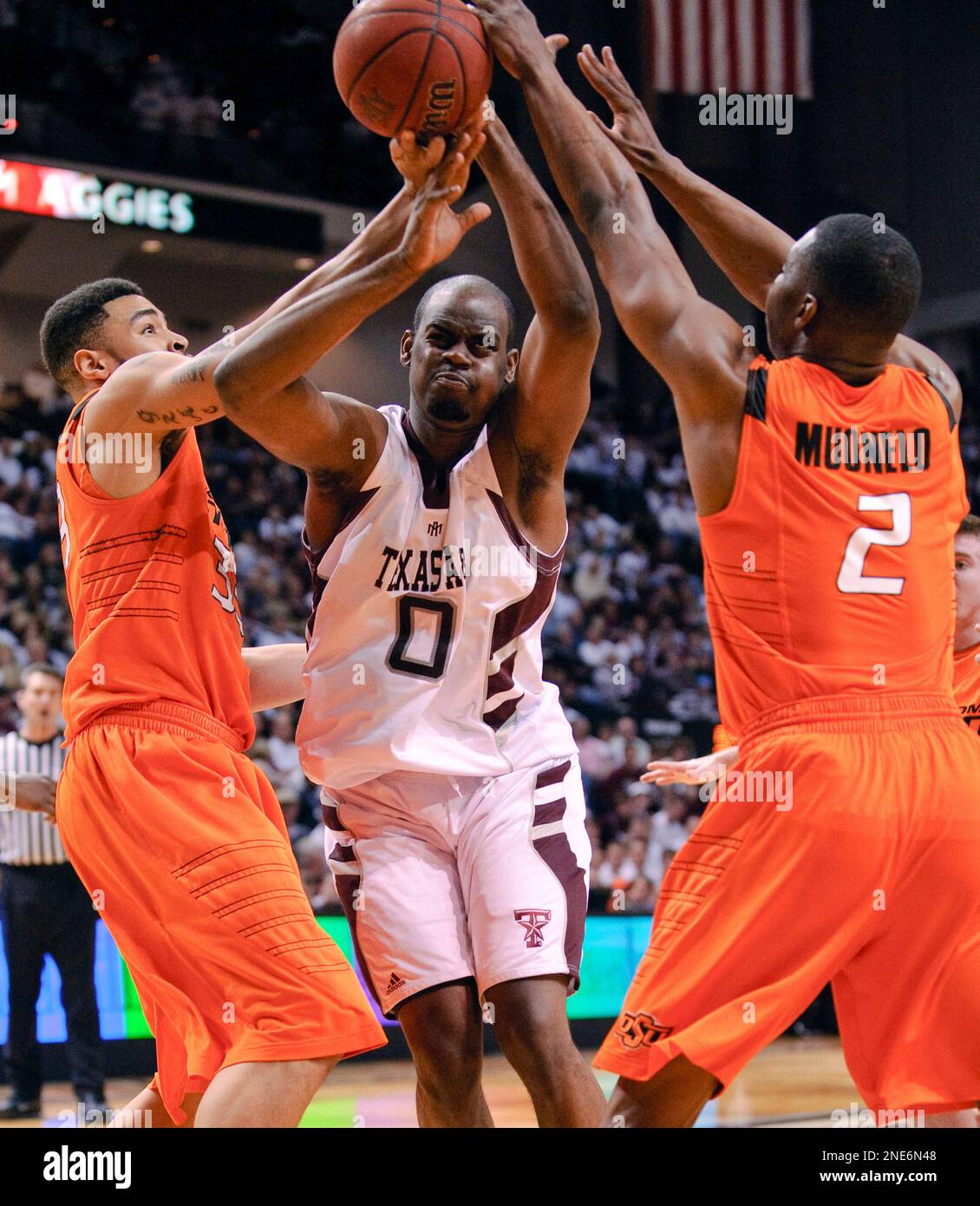 Texas A&M's Bryan Davis (0) drives between Oklahoma State's Marshall ...