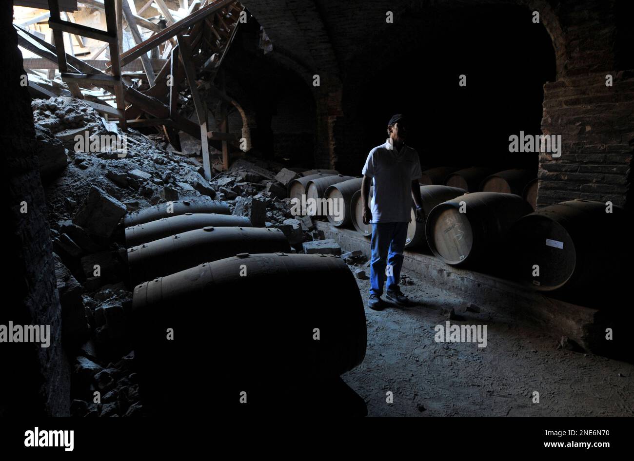 A man stands by wine barrels laying in the Santa Rita winery that ...