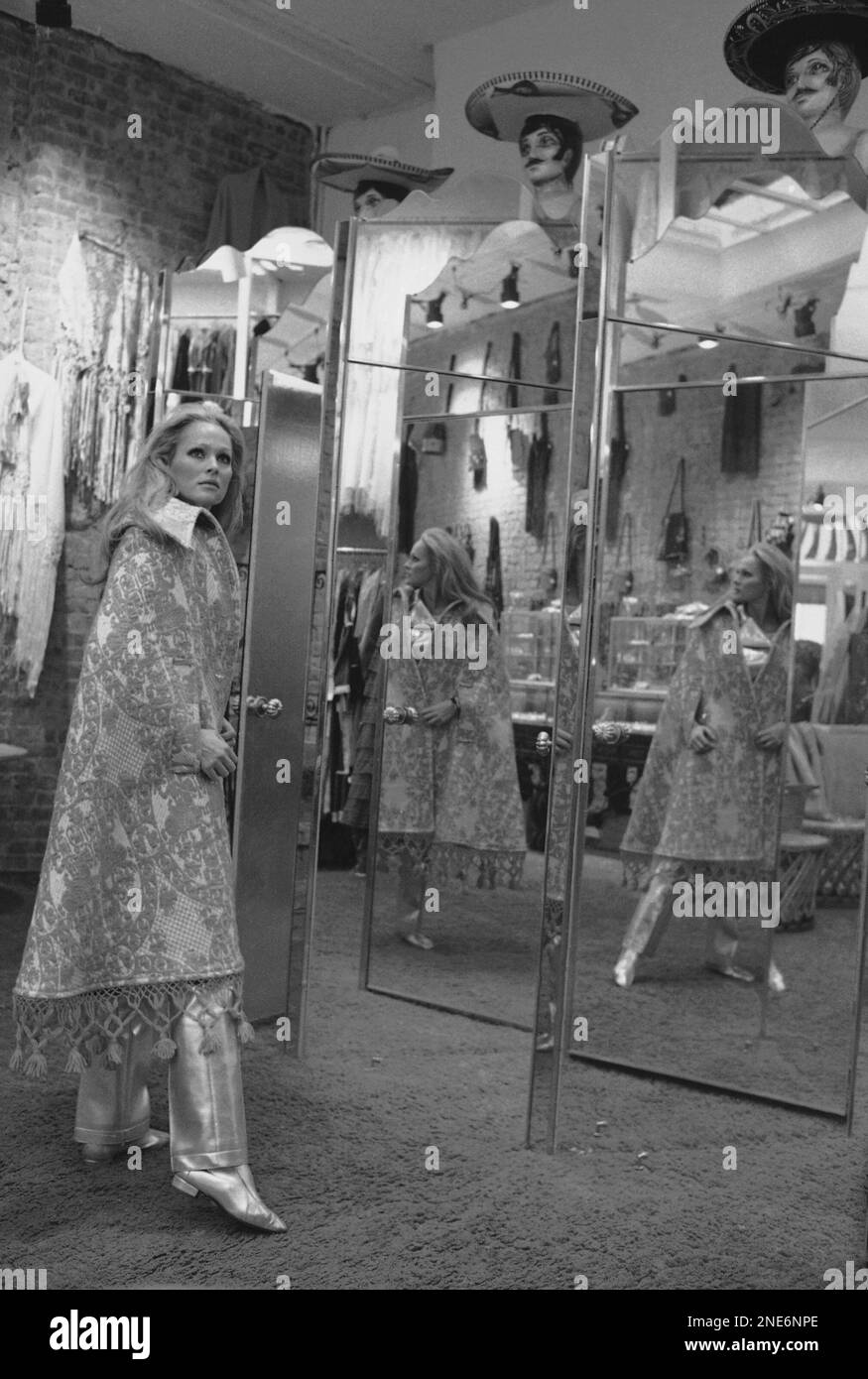 Actress Ursula Andress trying on capes in Fred Leighton's Mexican shop ...