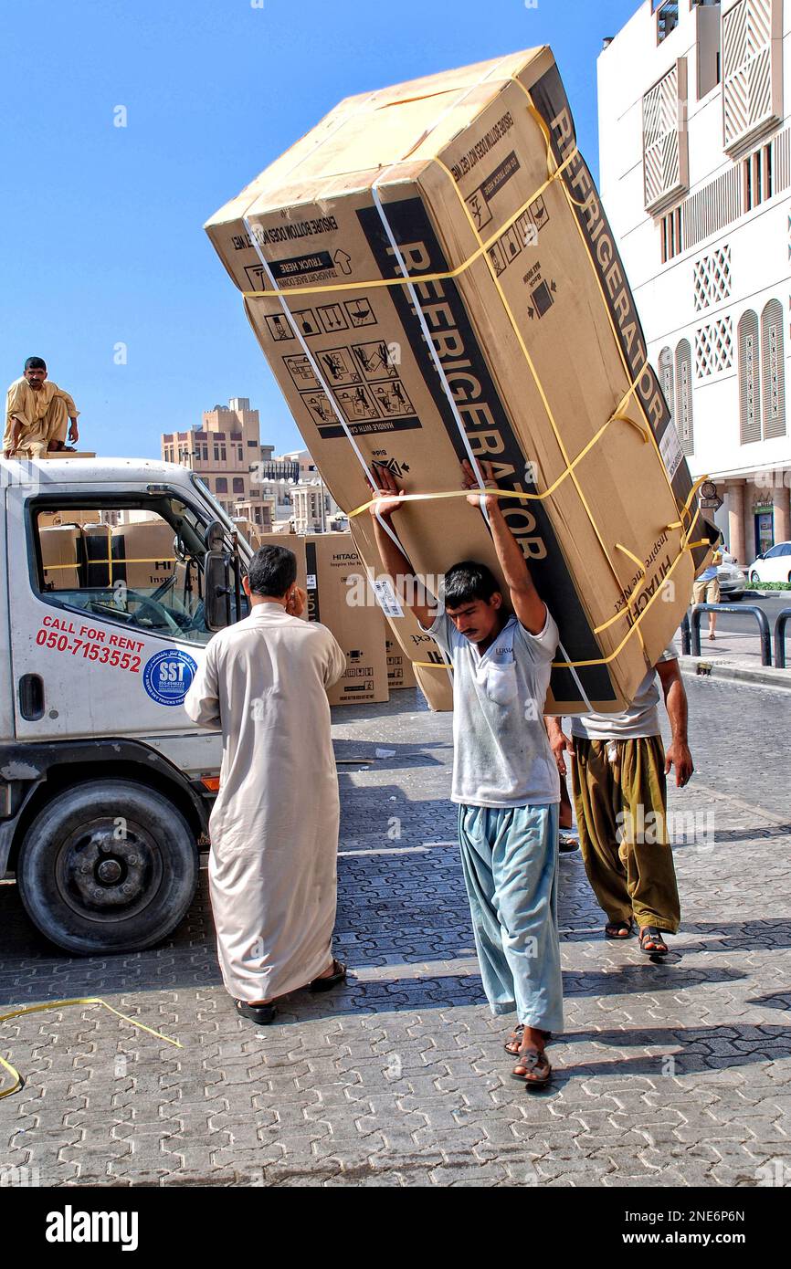 Heavy loads carried manually by Asian labour during loading on to an ...
