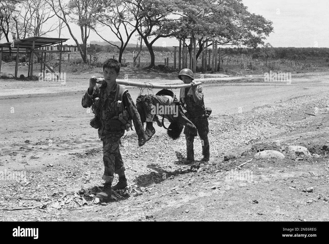 Two South Vietnamese soldiers carry the corpse of a fallen comrade from ...