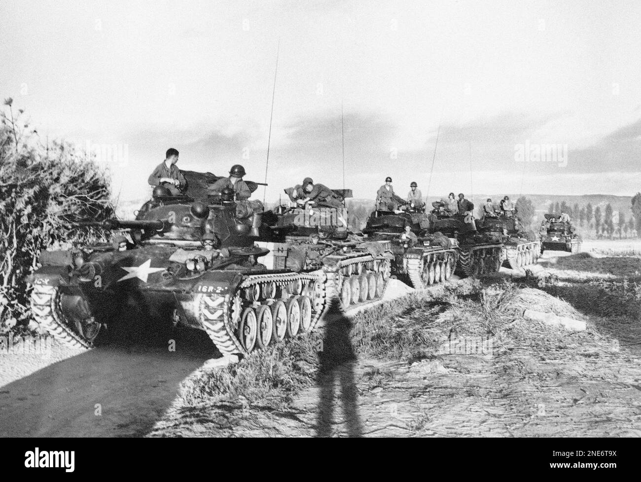 Six medium tanks, white stars painted for identification, move up to ...