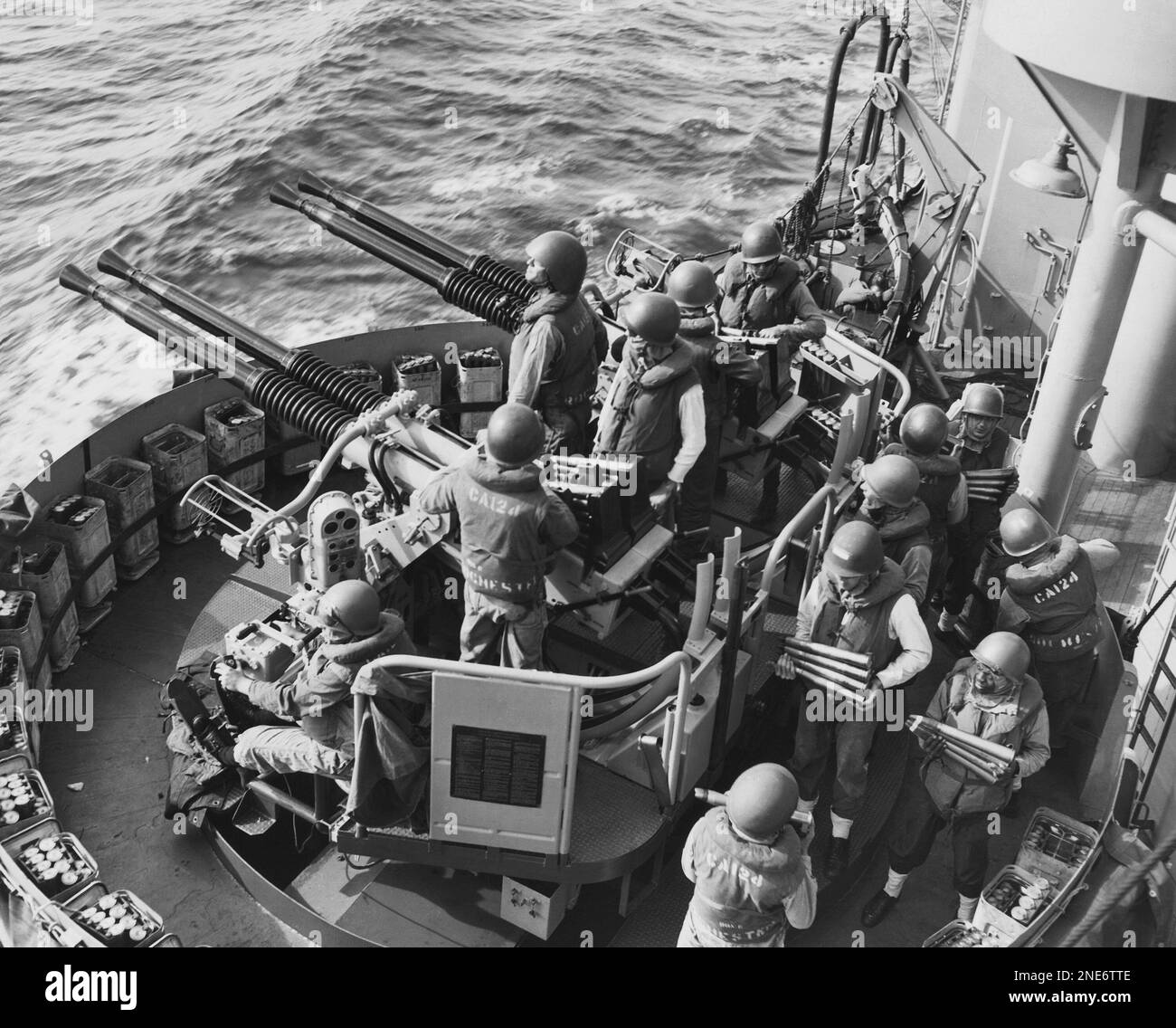 40-mm crew at station on a Heavy Cruiser during an air raid alert while ...