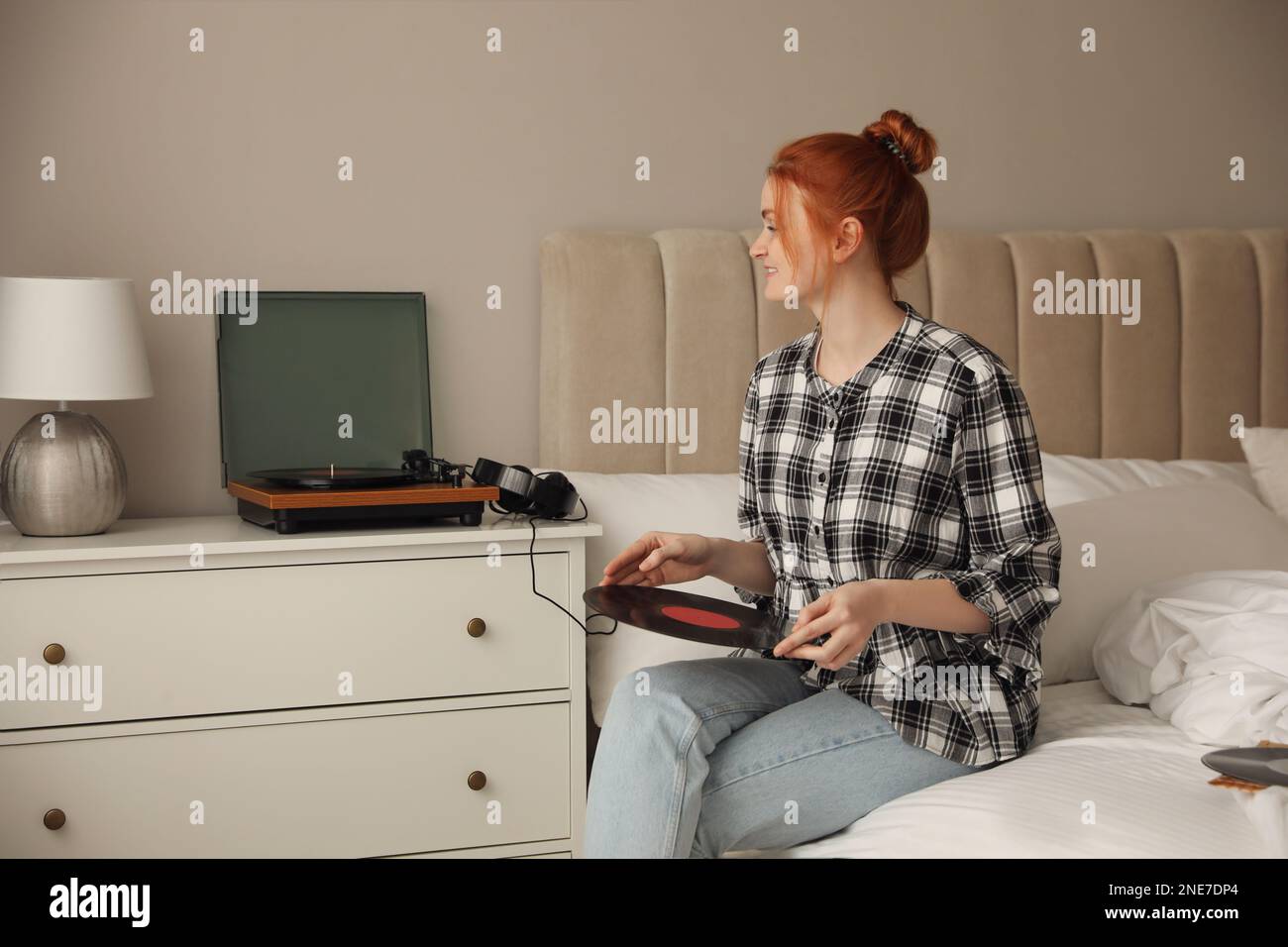 Young woman using turntable in bedroom at home Stock Photo - Alamy