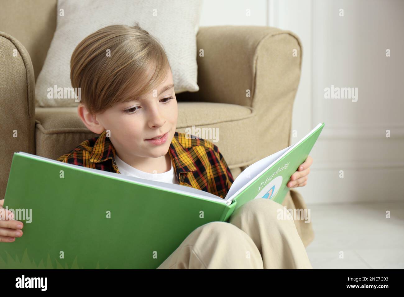 Little boy reading book on floor at home Stock Photo - Alamy