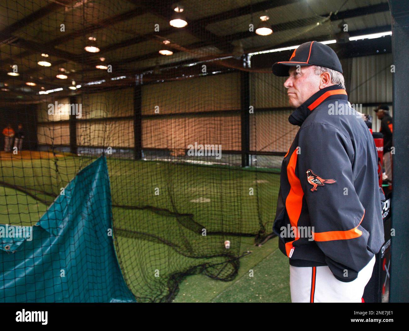 Baltimore Orioles manager Dave Trembley stands inside the batting cages ...