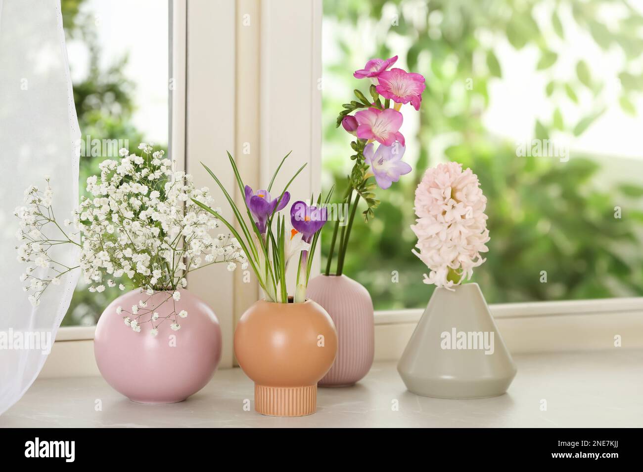 Beautiful fresh flowers on window sill indoors Stock Photo - Alamy