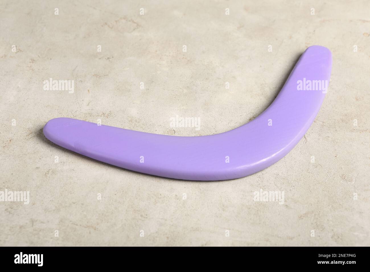 Purple boomerang on light grey background. Outdoors activity Stock ...