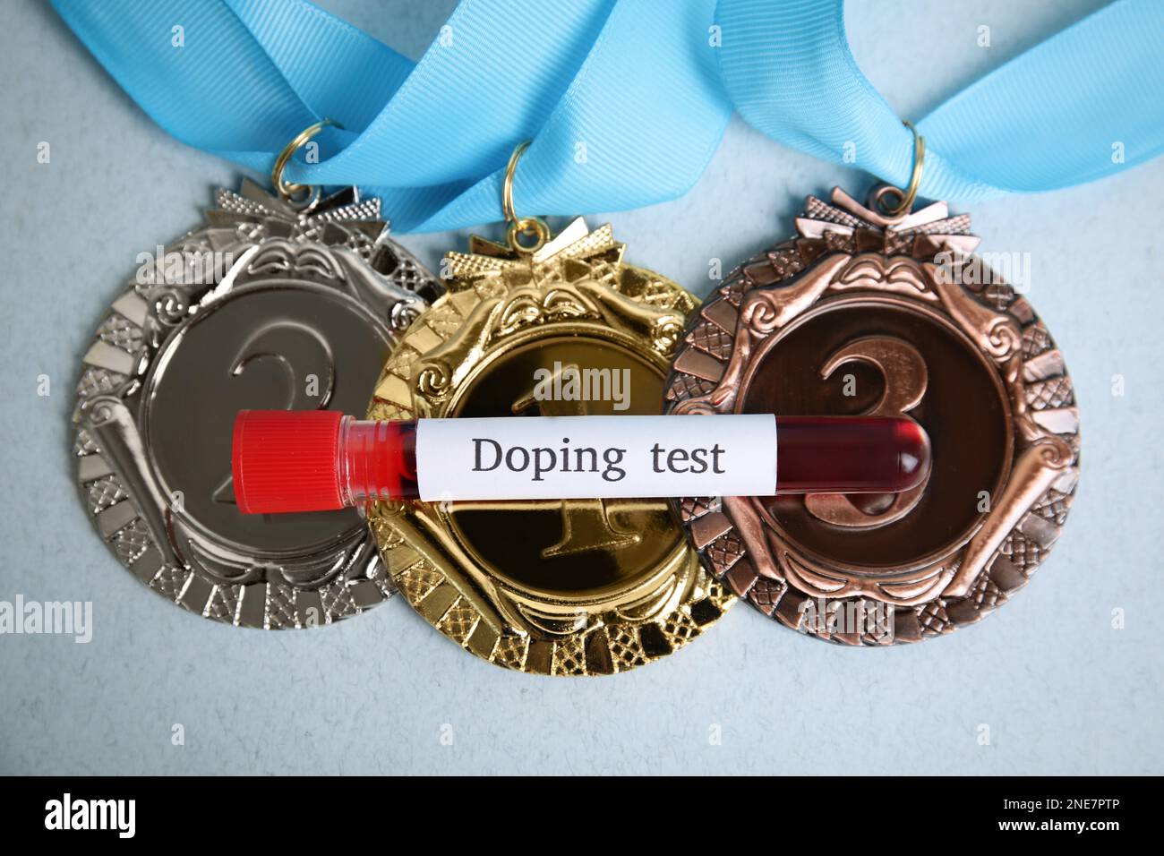 Medals and tube of blood with words Doping test on light blue ...