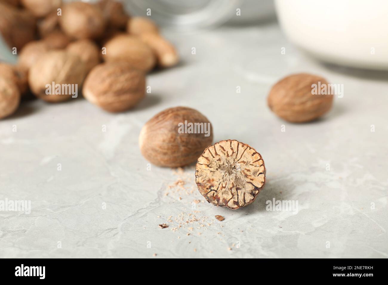 Whole and cut nutmeg seeds on light marble table Stock Photo - Alamy