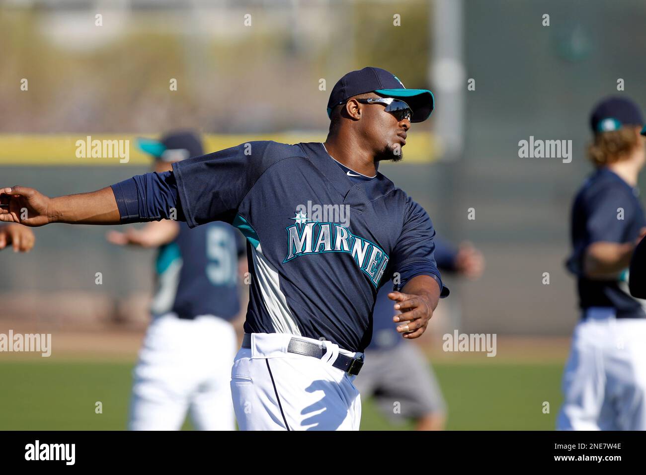 Seattle Mariners left fielder Mike Wilson stretches with teammates ...