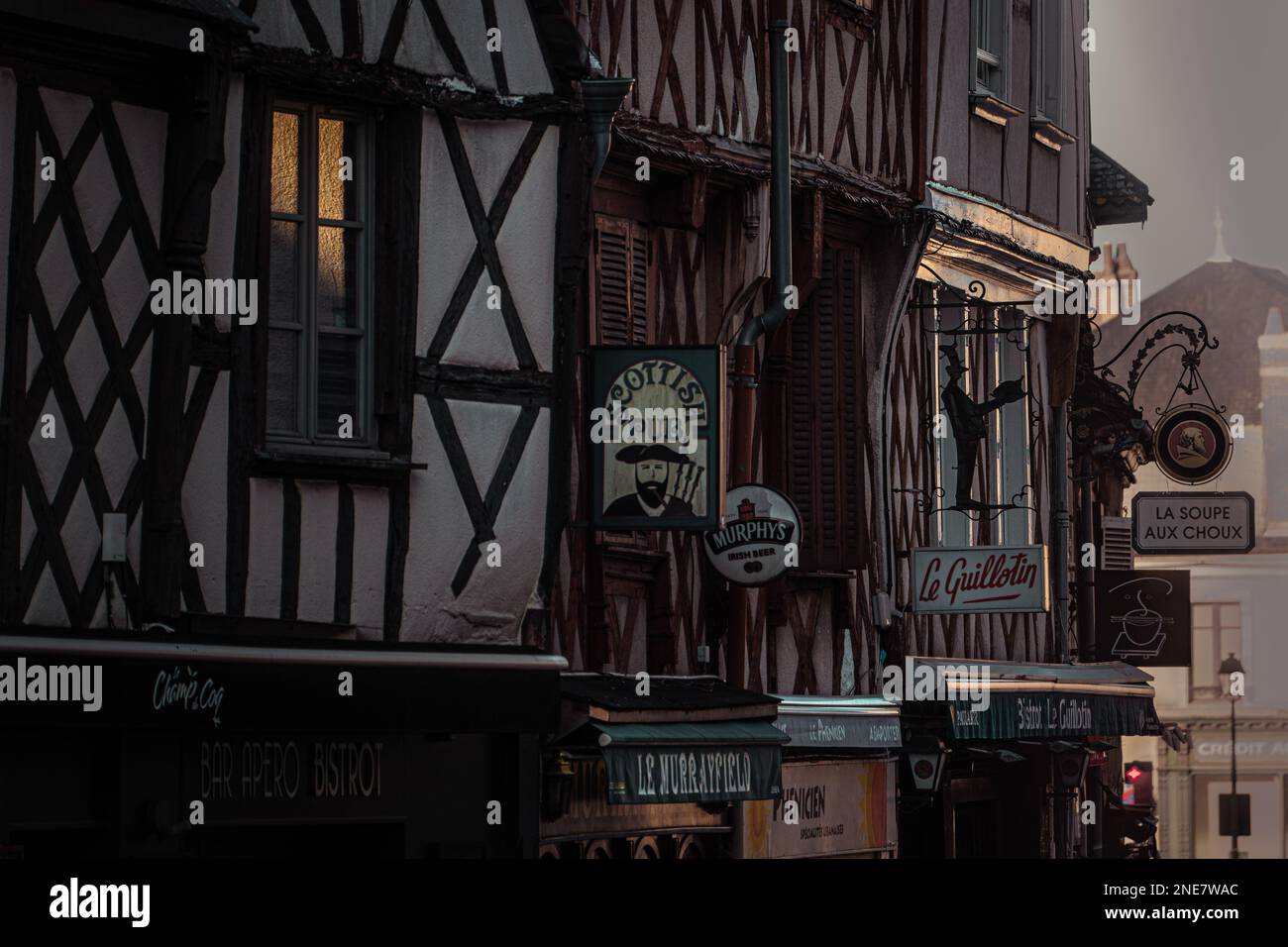 The street signs of the pubs and cafes at the facade of the buildings ...