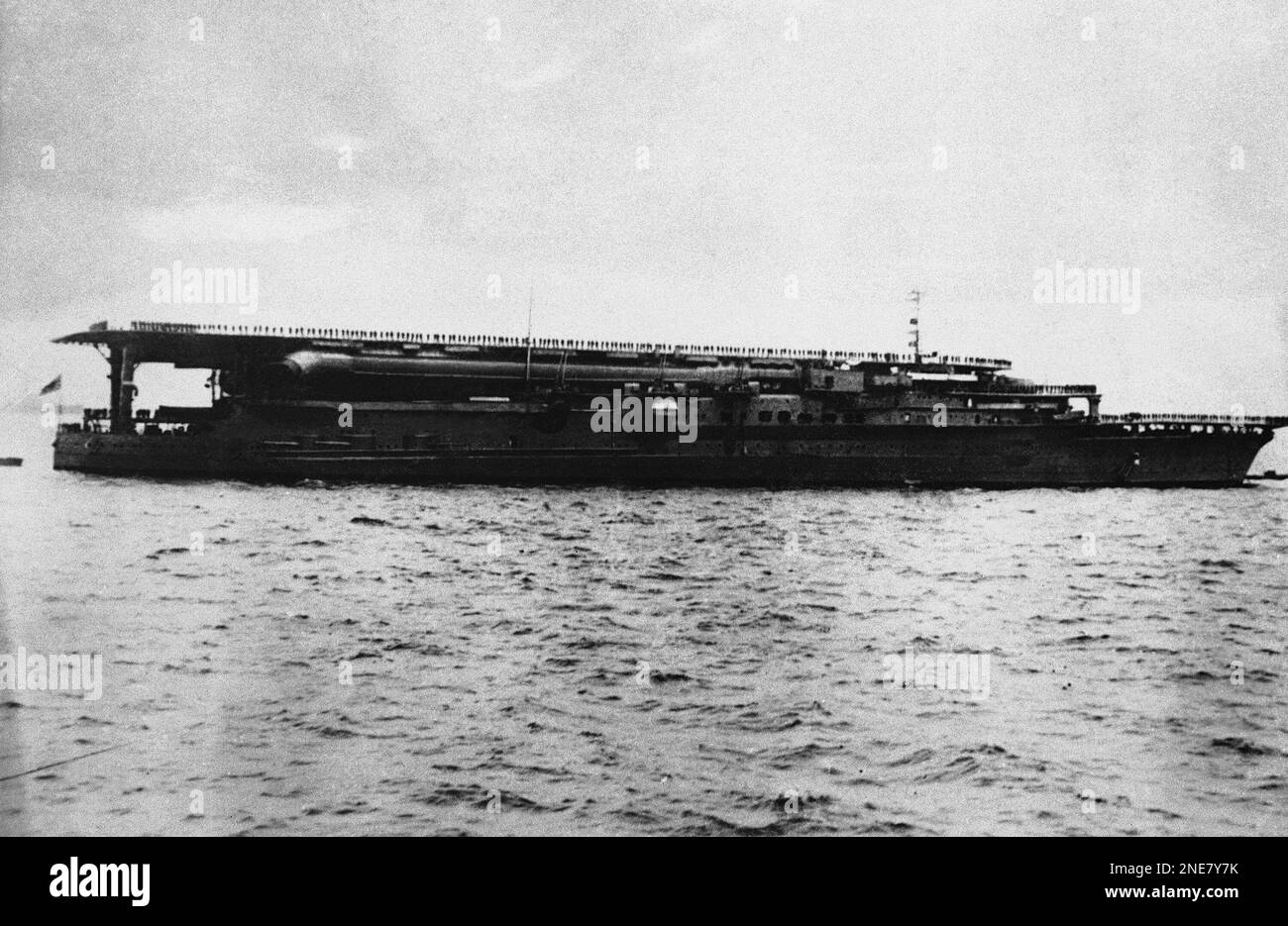 Crew of the 26,000 ton Japanese aircraft carrier Kobe line the deck ...