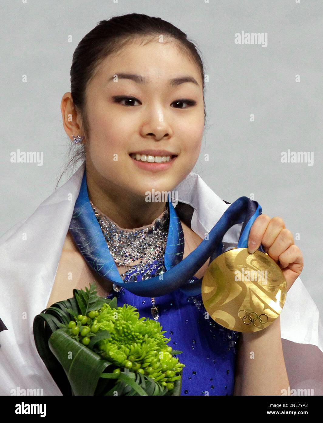 South Korea's Kim Yu-Na poses with the gold medal during the medals ceremony for the women's ...
