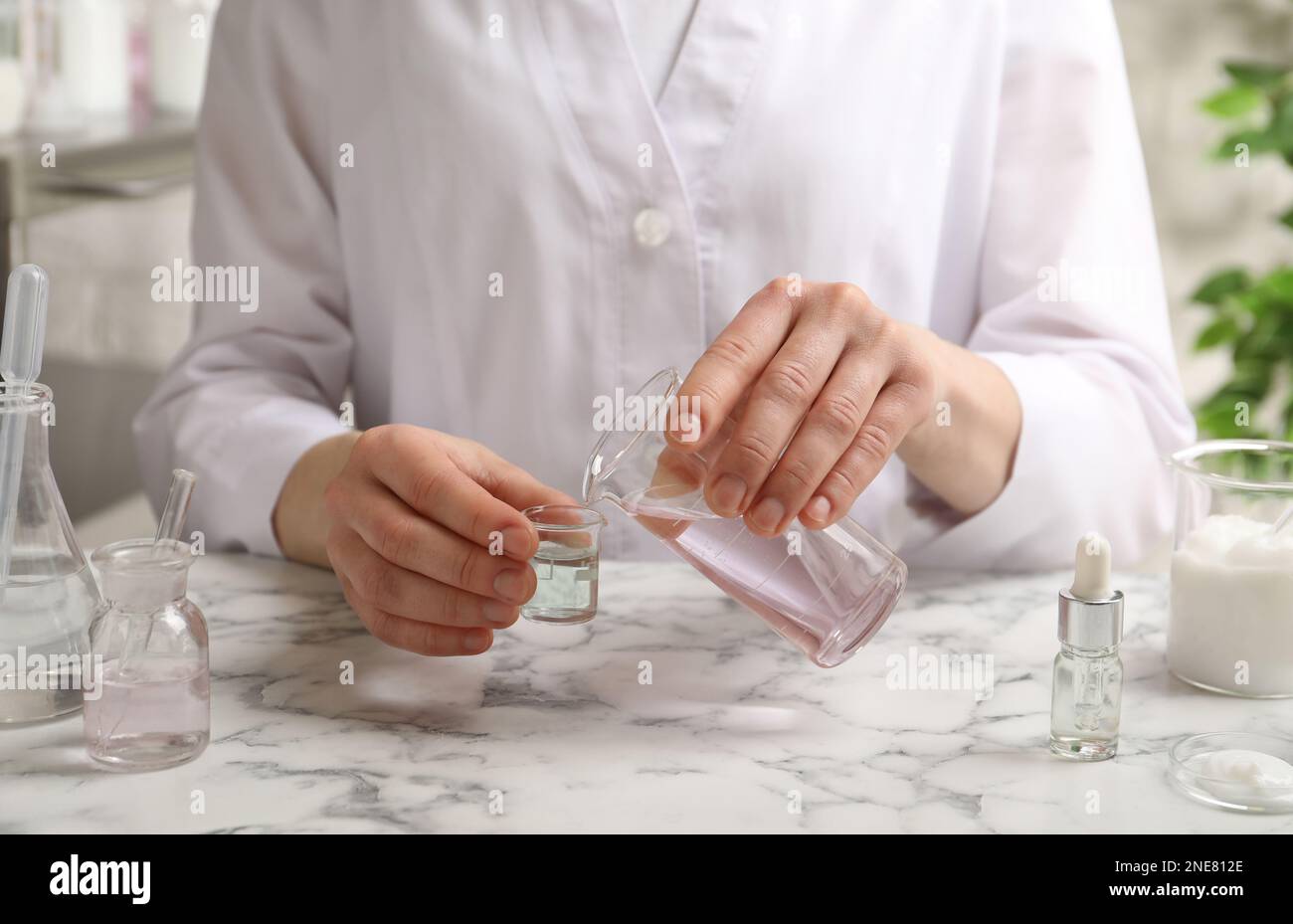 Scientist testing cosmetic product at white marble table in laboratory ...