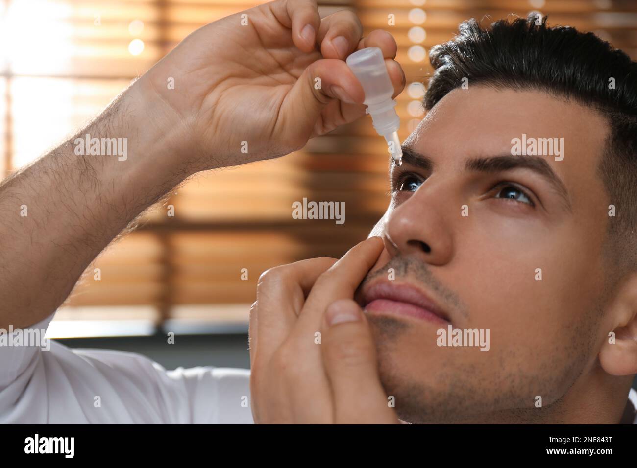 Man using eye drops near window indoors, closeup Stock Photo - Alamy