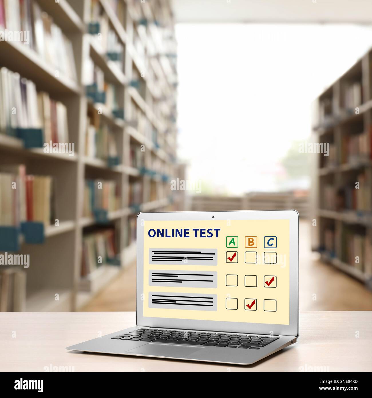 Laptop with online test on screen in library Stock Photo - Alamy