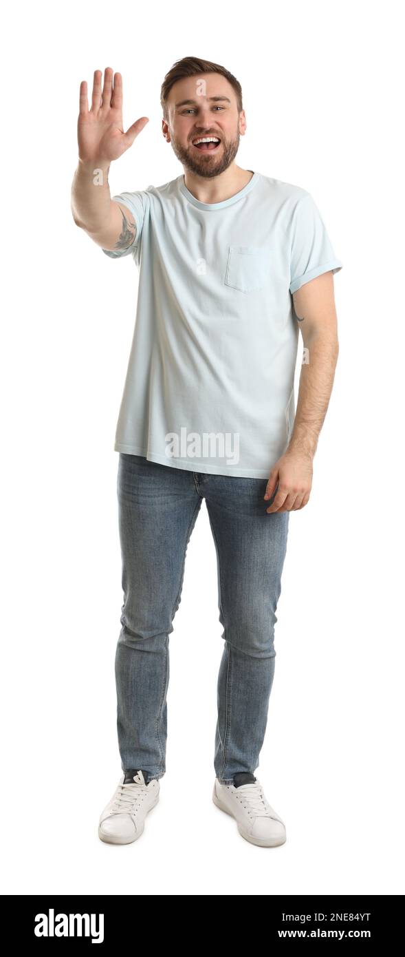 Happy young man waving to say hello on white background Stock Photo - Alamy