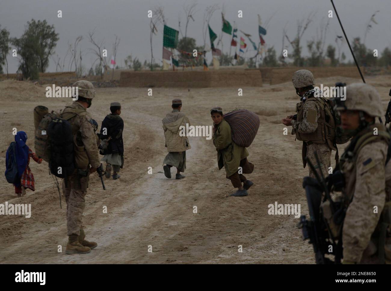 An Afghan boy looks back as U.S. Marines from 3rd Battalion, 6th Marine ...