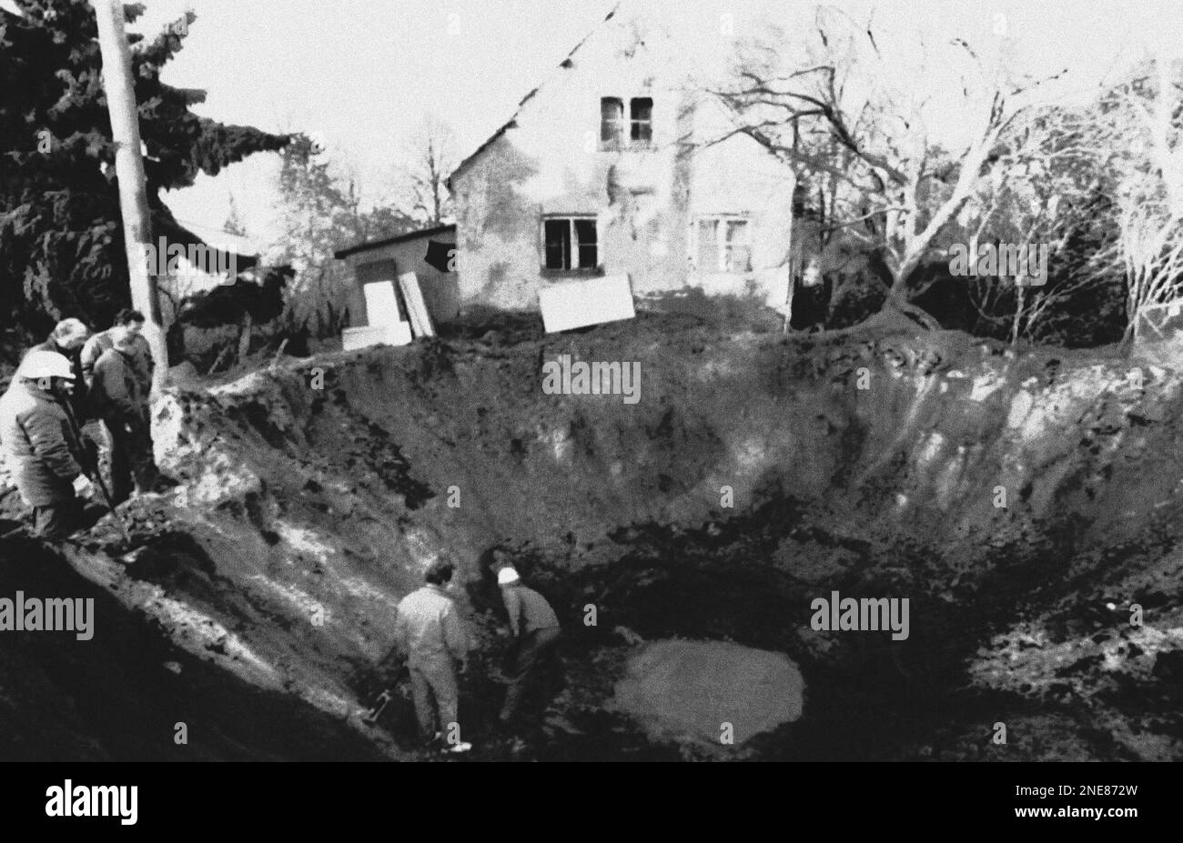 Workmen clear out the crater of a World War II era bomb, Dec. 5, 1991 ...