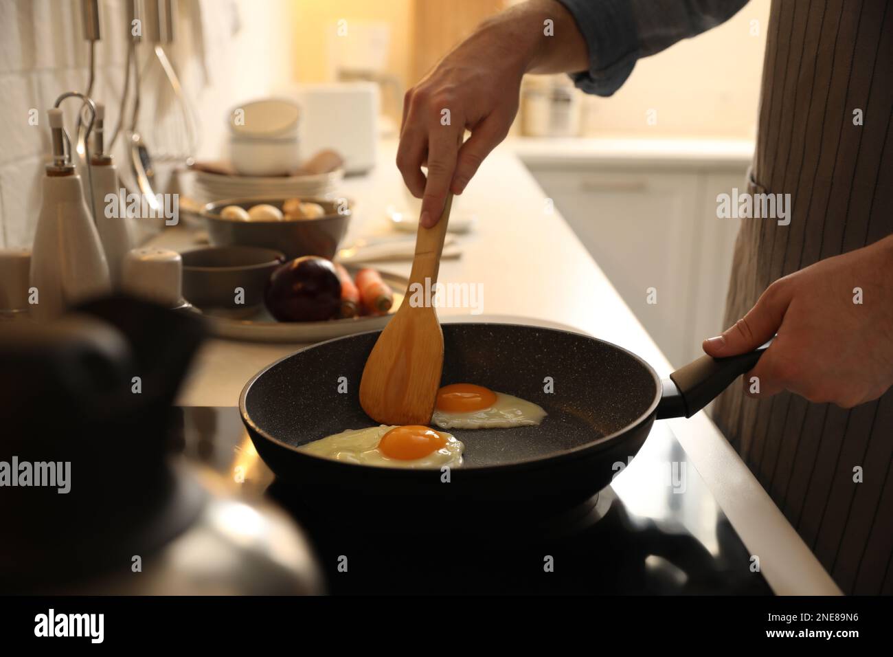 Man cooking eggs in frying pan, closeup Stock Photo - Alamy