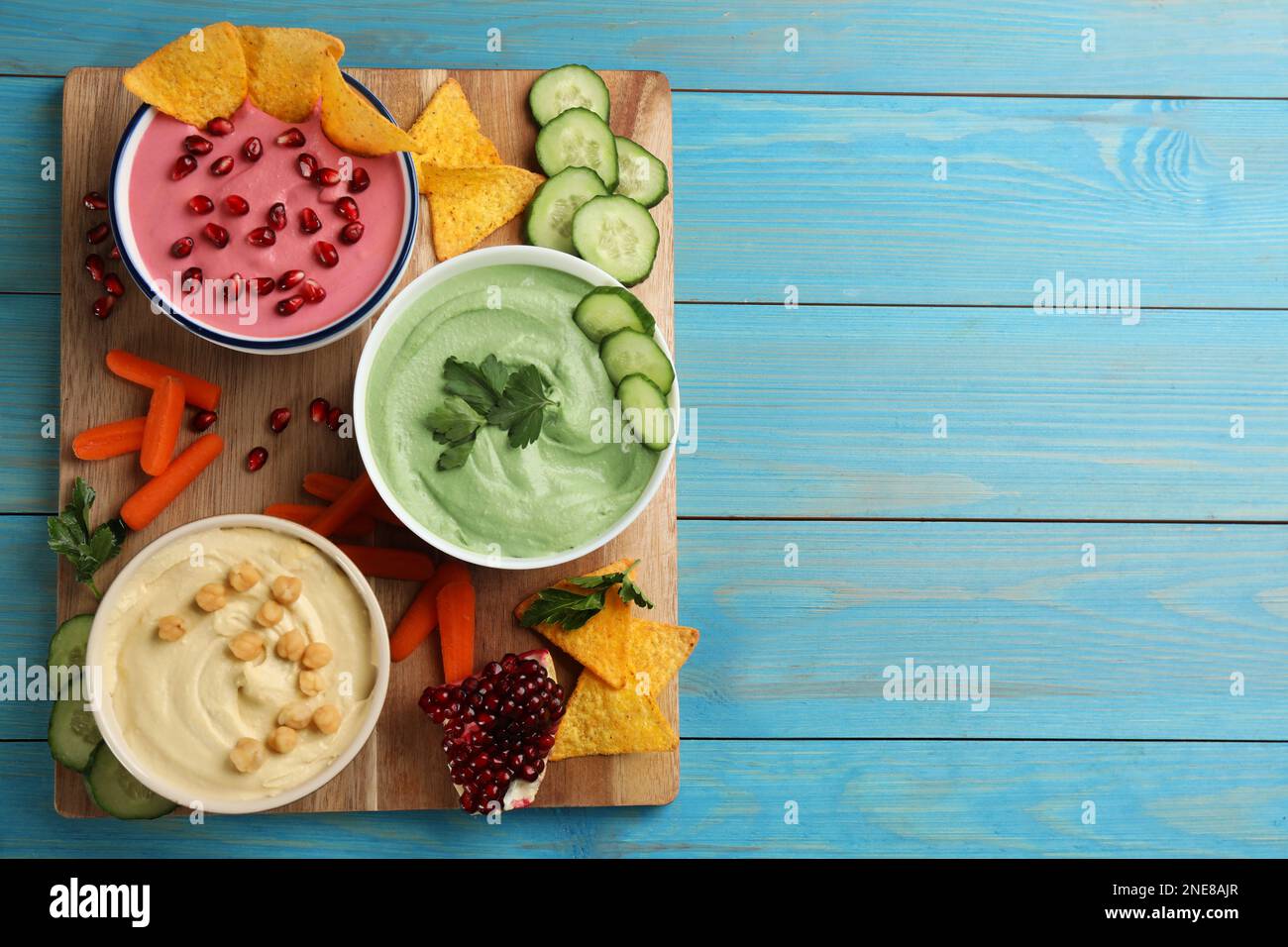 Composition with delicious hummuses on light blue wooden table, top ...