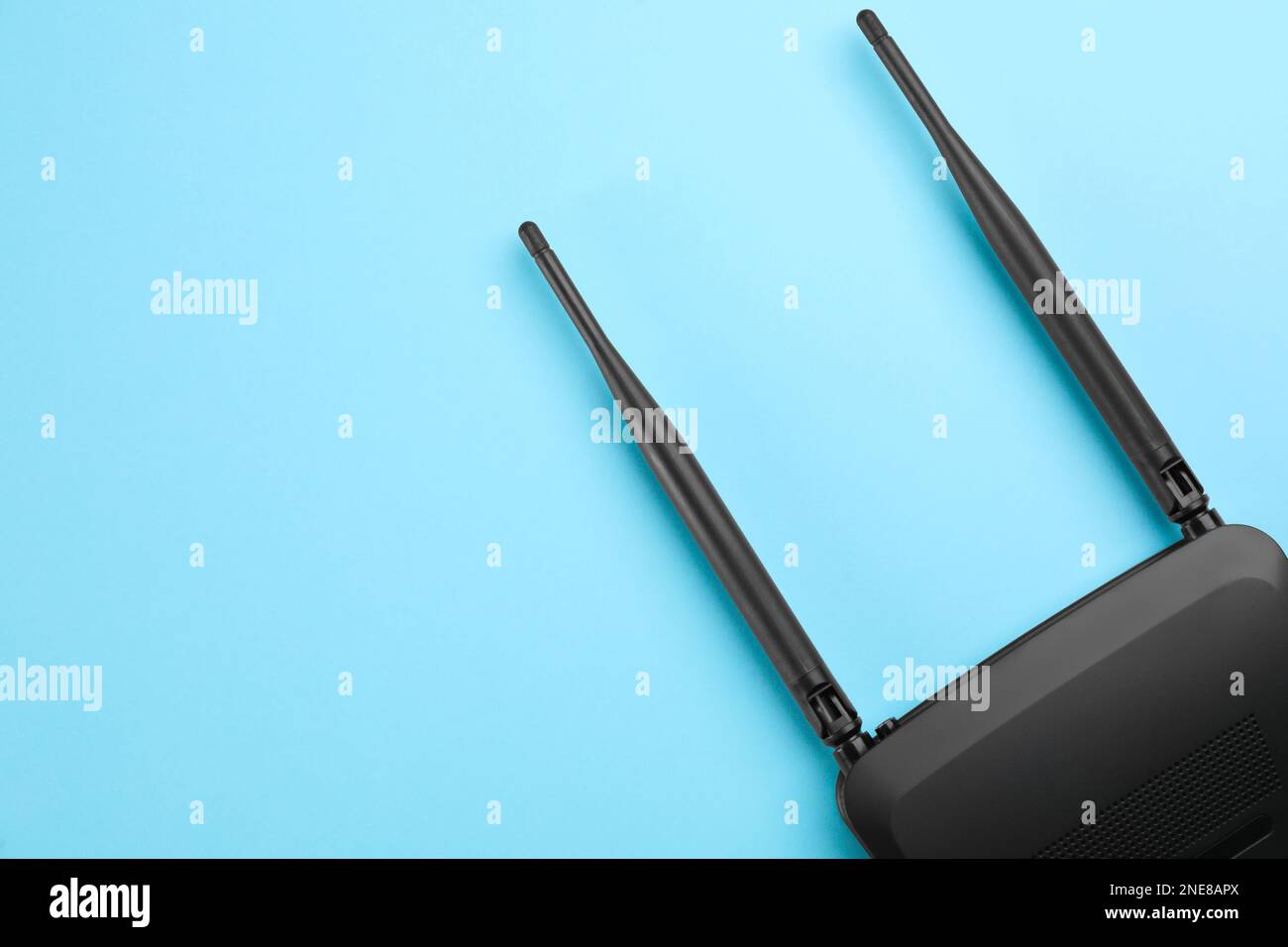 Modern Wi-Fi router on light blue background, top view. Space for text ...