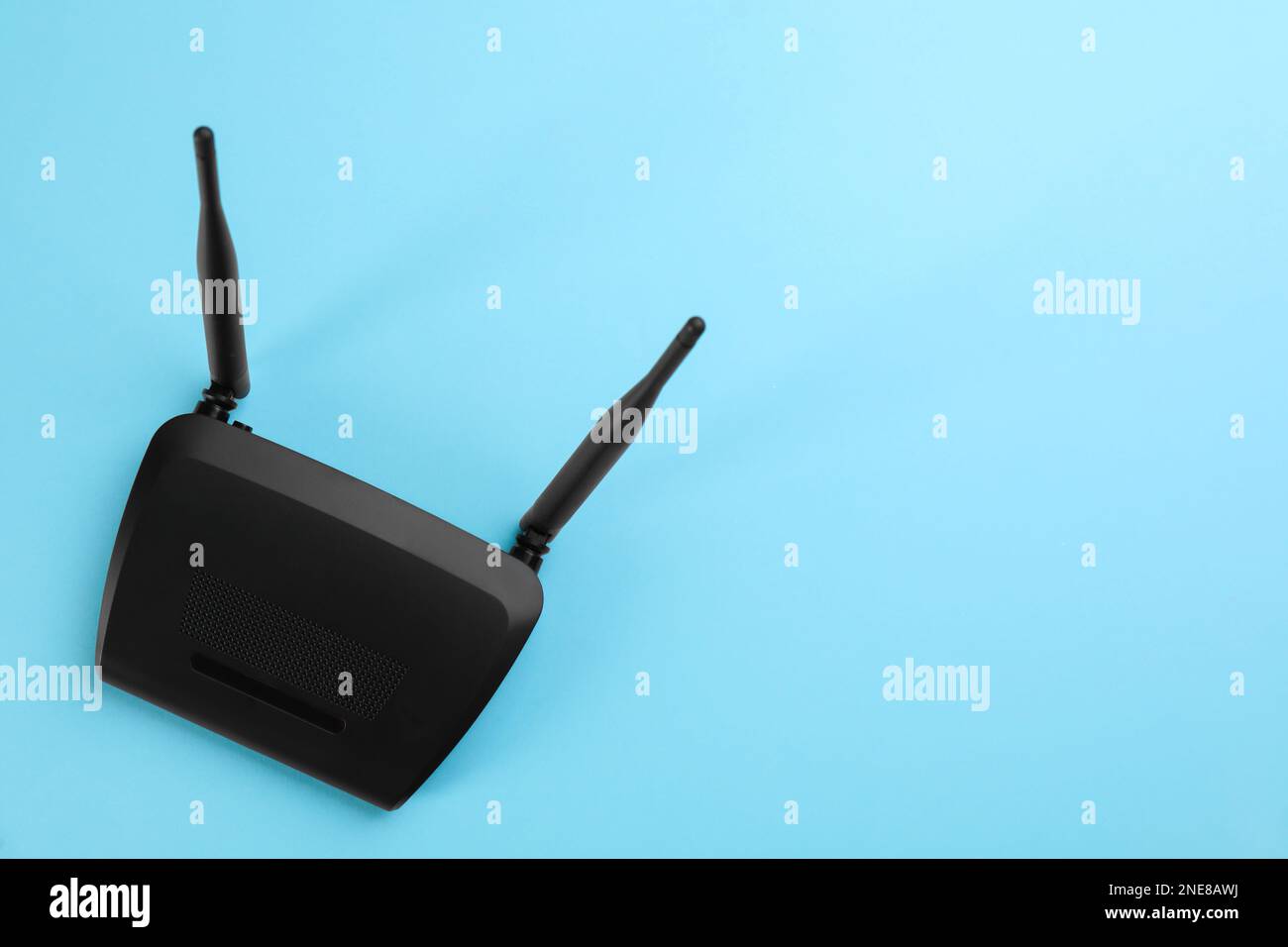 Modern Wi-Fi router on light blue background, top view. Space for text ...