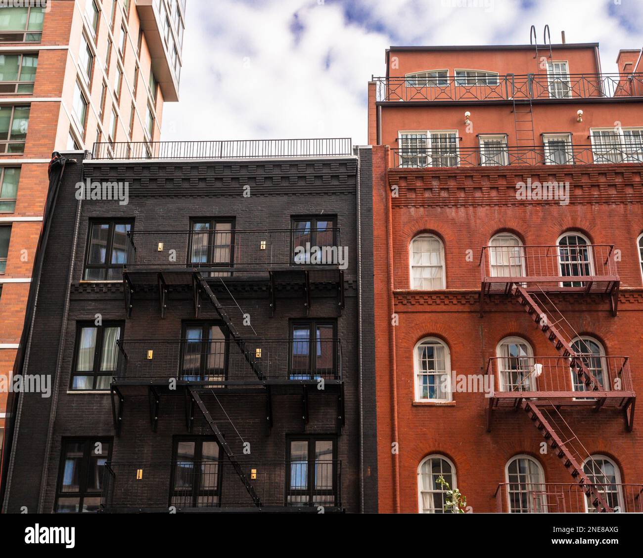 City brick apartment building exterior with fire escapes Stock Photo ...