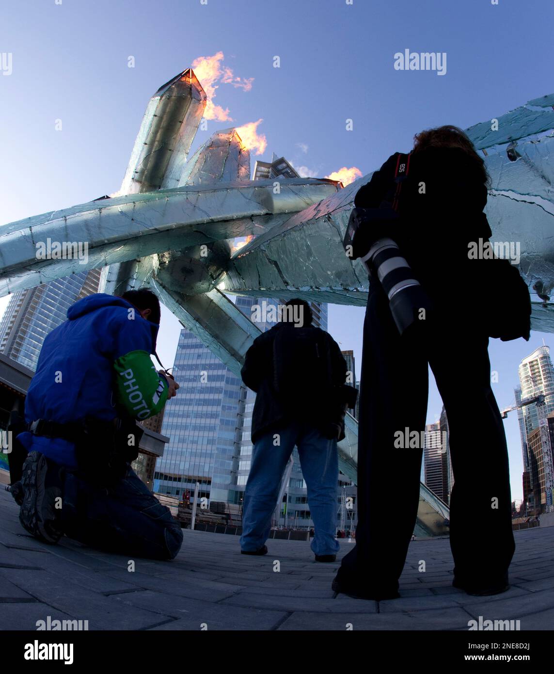 Photographers take pictures of the Olympic cauldron during a tour at ...