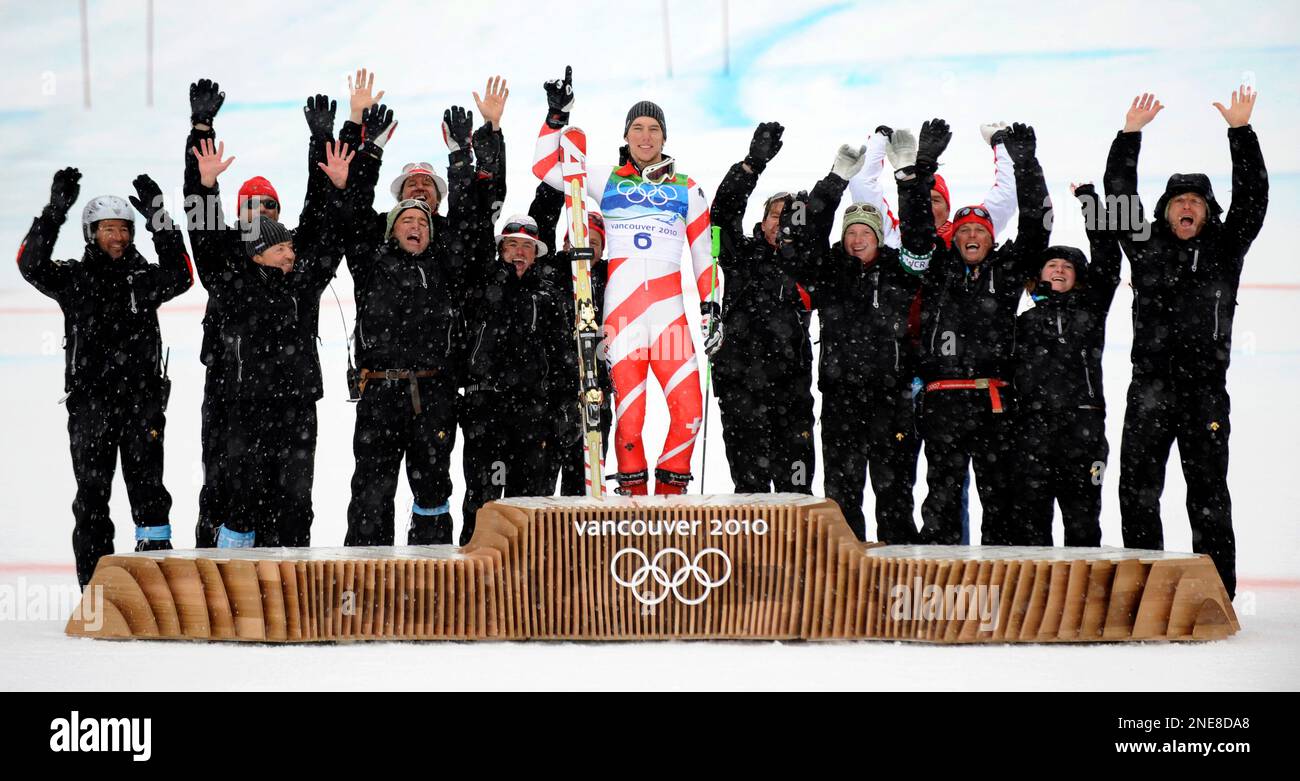 Gold medalist Carlo Janka, of Switzerland, is flanked by members of the ...