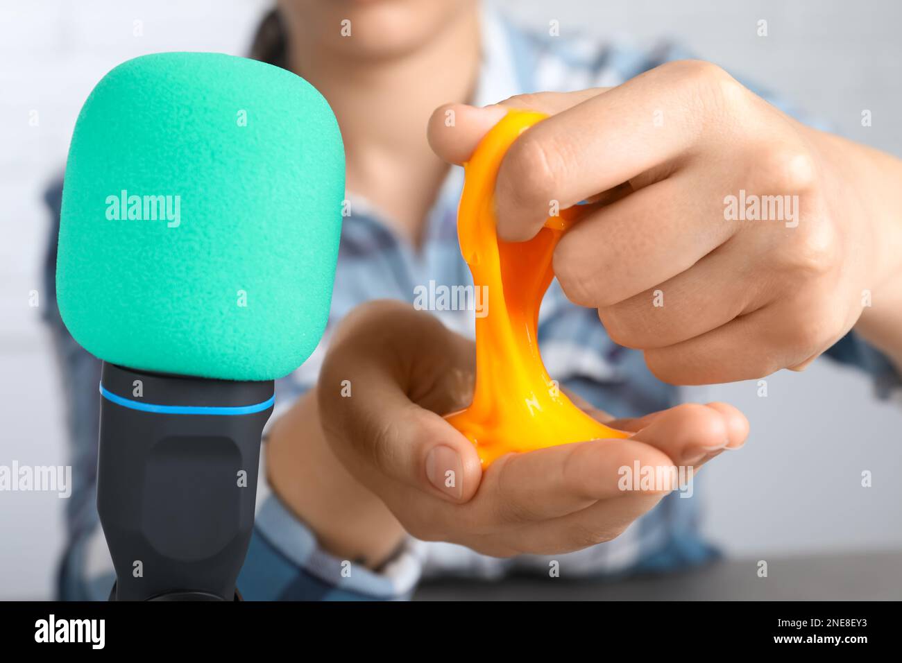 Woman making ASMR sounds with microphone and bright slime, closeup ...