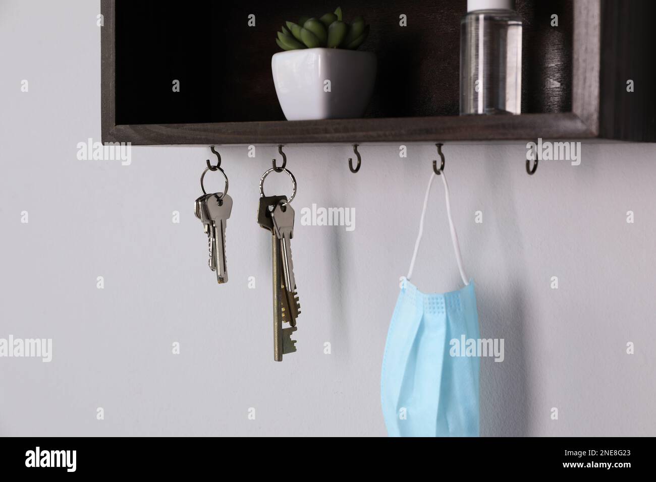 Wooden hanger for keys with different stuff on light grey wall Stock ...