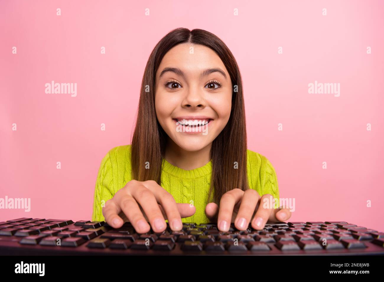 Photo portrait of pretty young schoolgirl typing computer keyboard ...