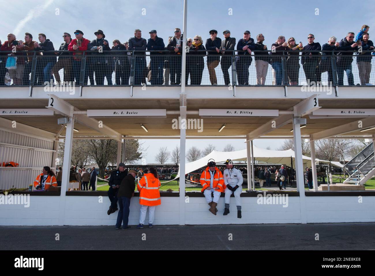 Spectators standing on the Pit Lane Roof Viewing & marshals sitting on ...