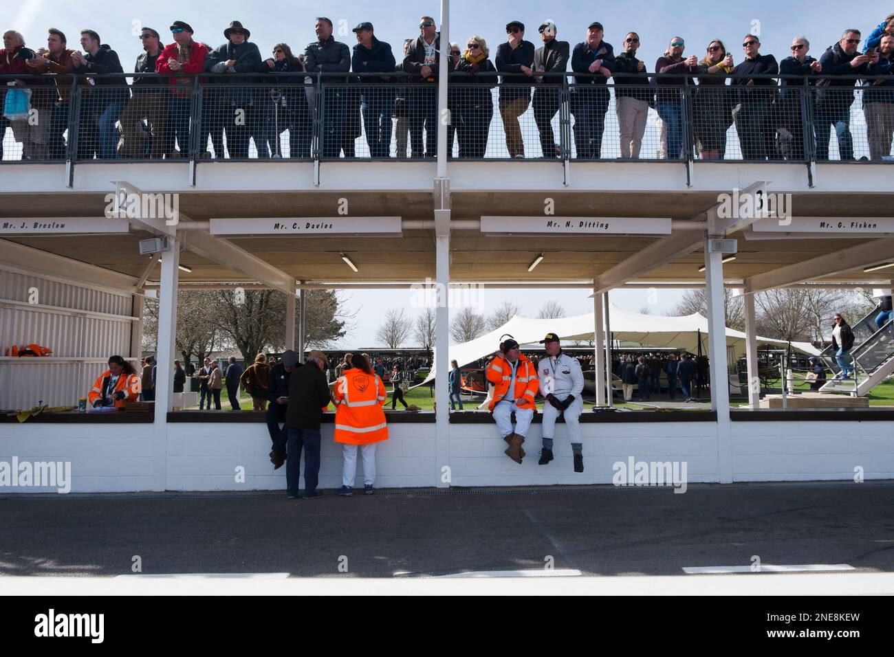Spectators standing on the Pit Lane Roof Viewing & marshals sitting on ...