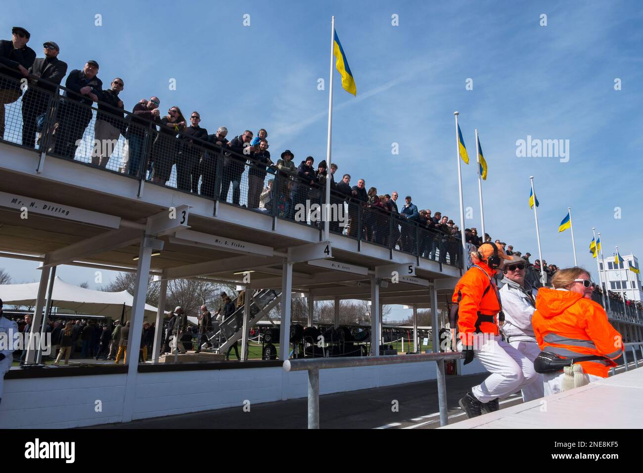 Spectators standing on the Pit Lane Roof Viewing & marshals sitting on ...