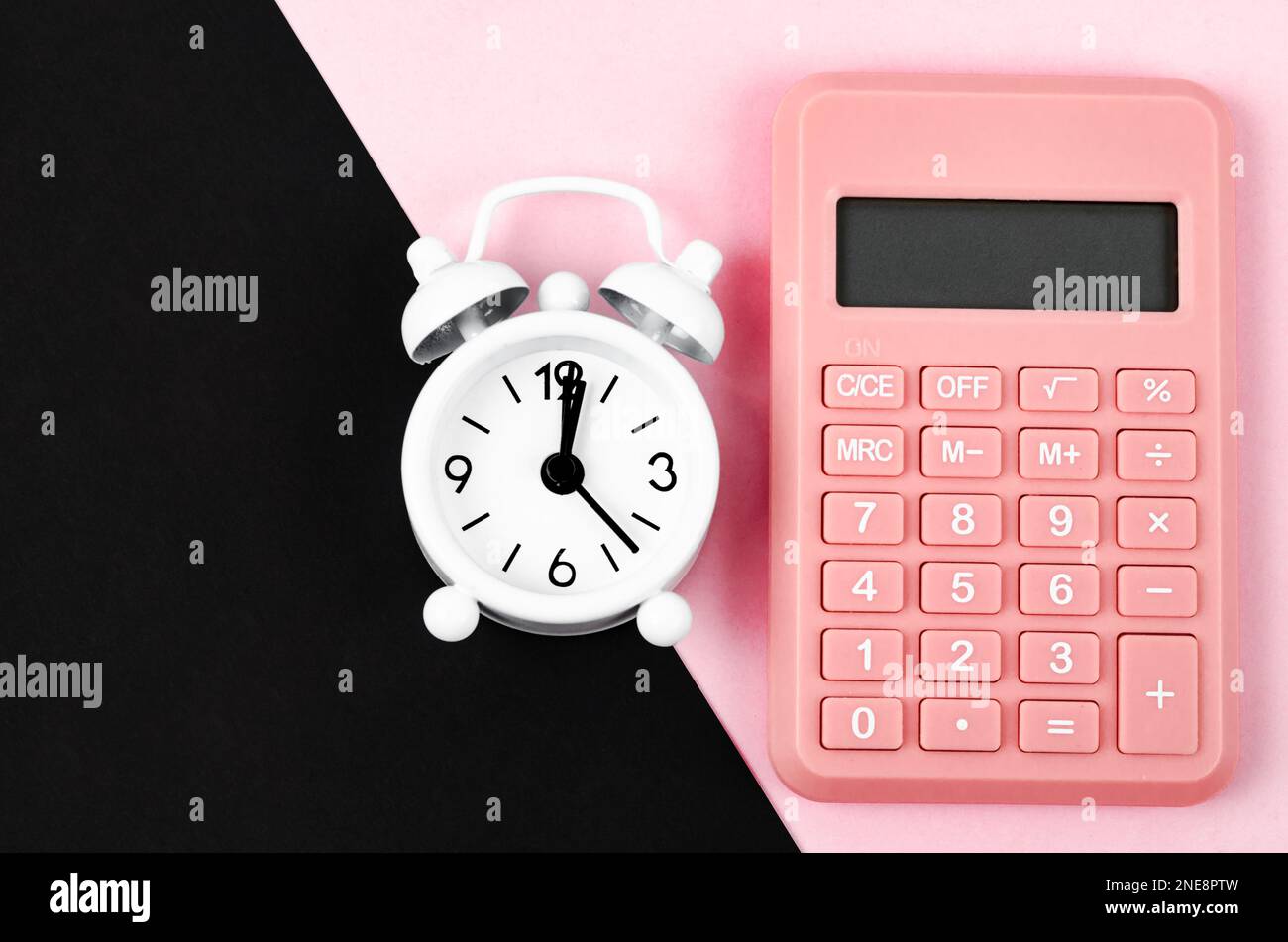 Calculator and alarm clock on pink and black background. Top view. Flat ...