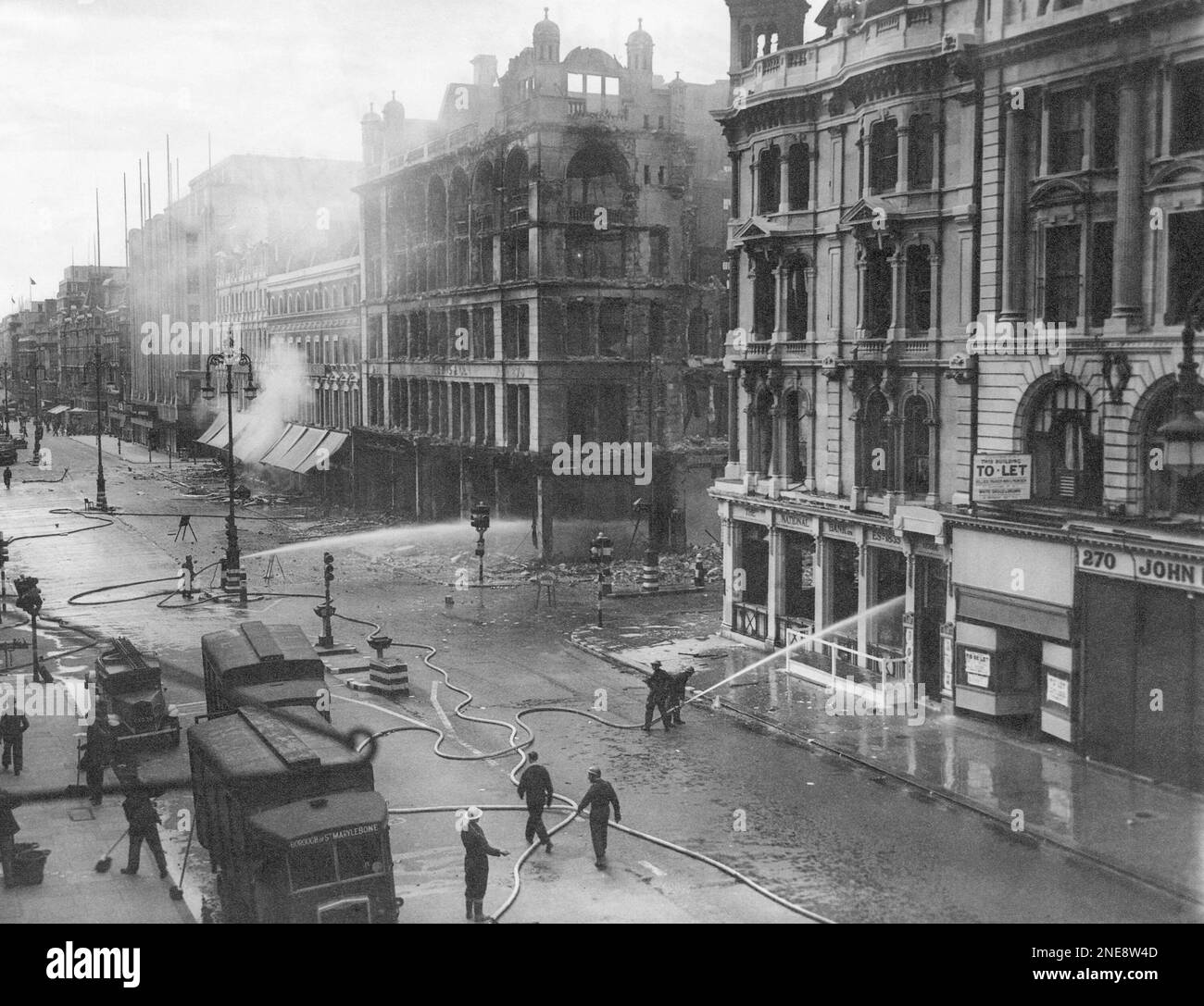 Firemen play to their hoses on the smouldering ruins of John Lewis?s in ...
