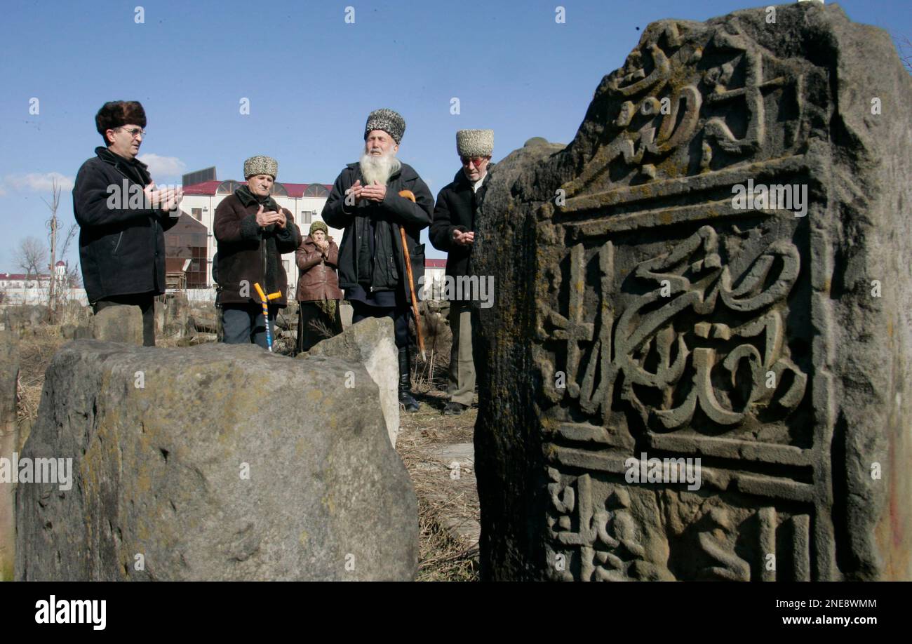 Chechen elderly men pray at a cemetery, a memorial to the Stalin-era ...