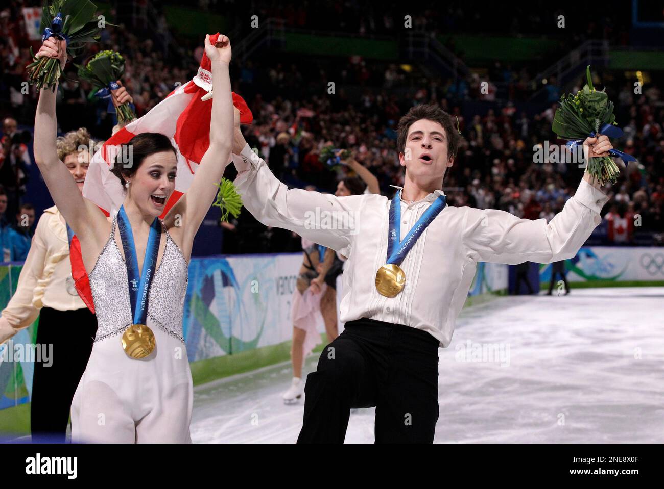 Canada's Tessa Virtue and Scott Moir skate a victory lap after winning ...