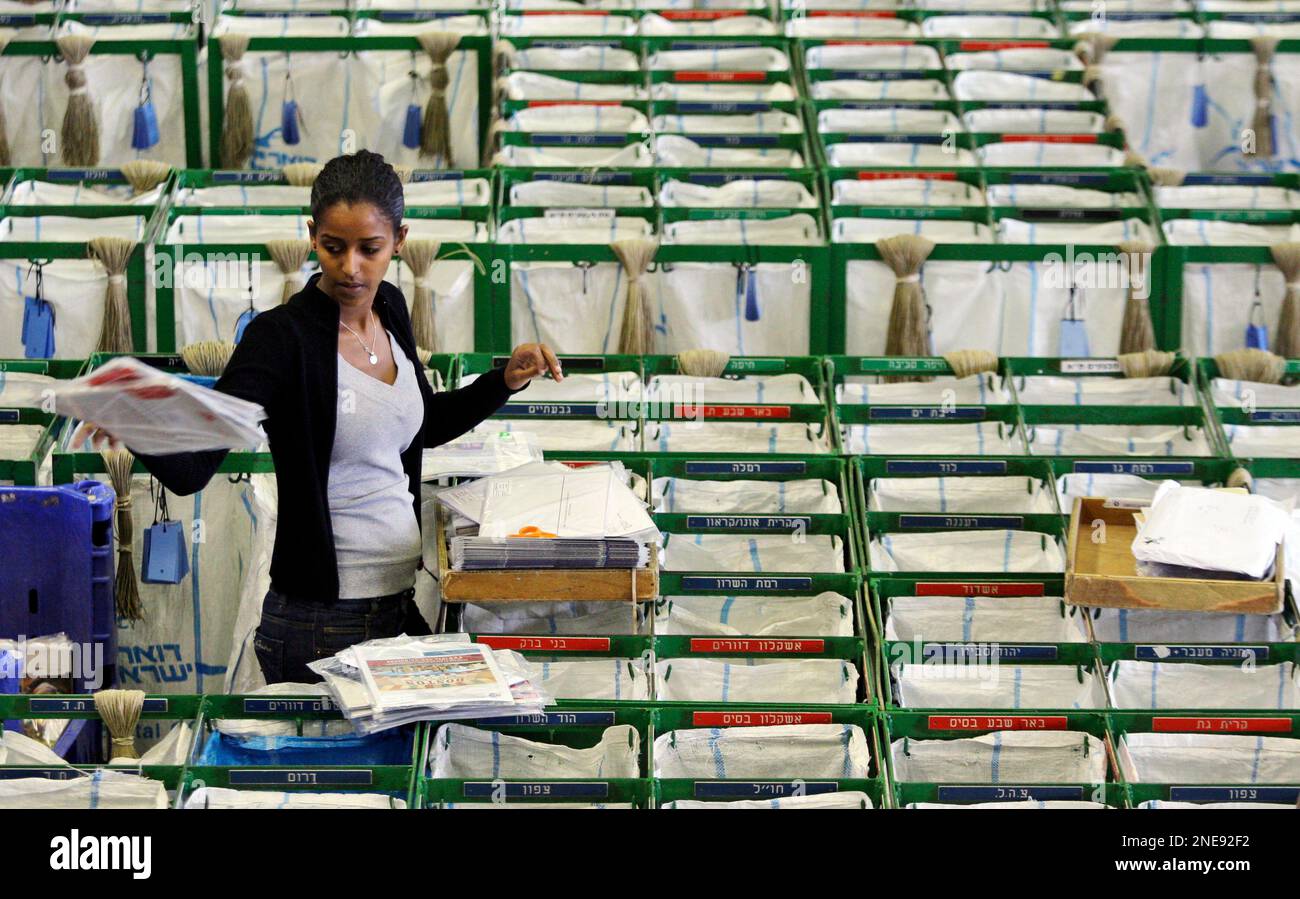 An Israeli postal authority worker sorts out mail at a post office in ...