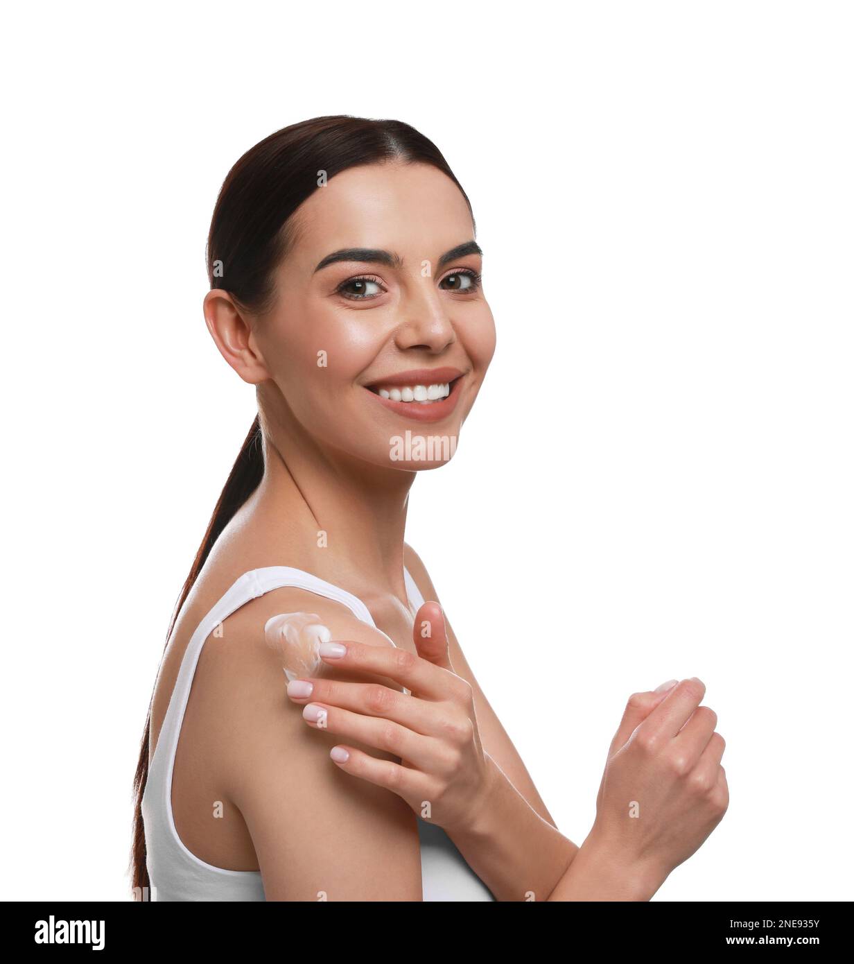 Young woman applying body cream onto her shoulder against white ...
